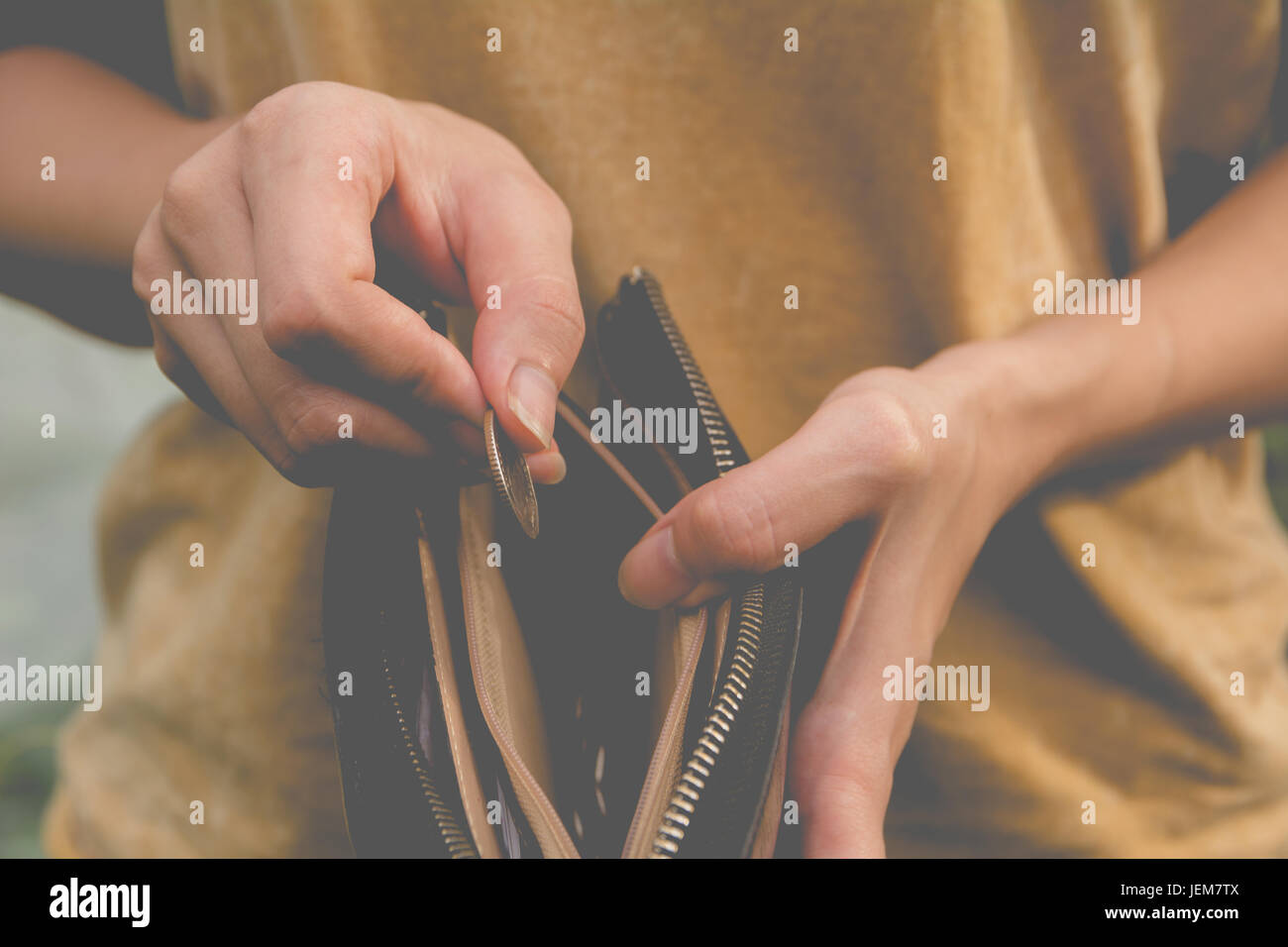 Close-up woman standing and holding money coin with wallet empty of ...