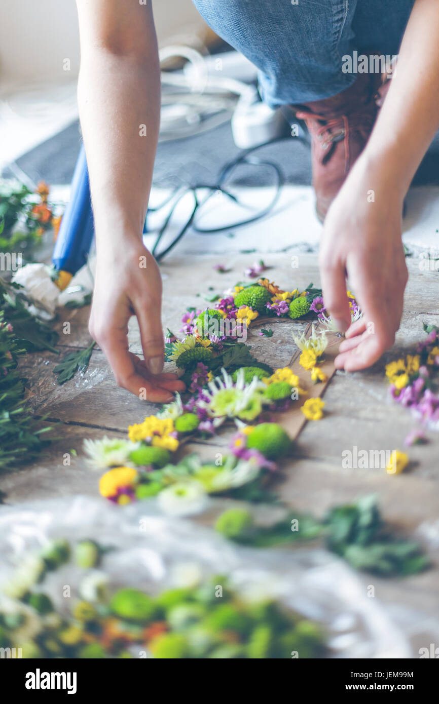 Florist making flower decoration with letters and glue. Indoors natural ...