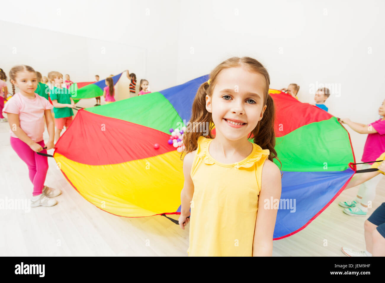 Smiling little girl playing parachute games in gym Stock Photo - Alamy
