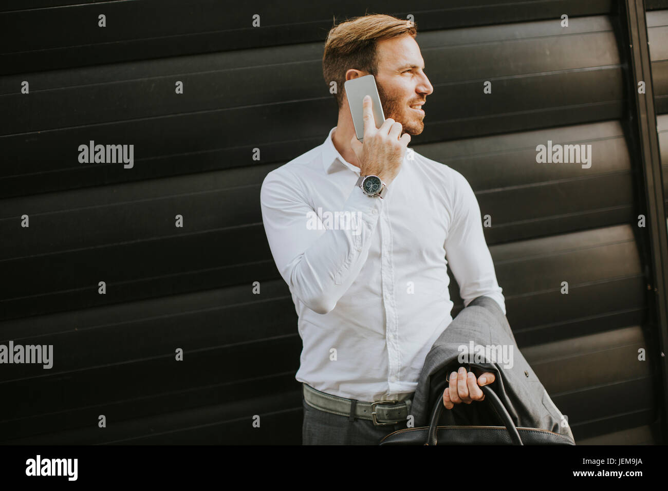 View at Young successful men entrepreneur using mobile phone outdoor ...