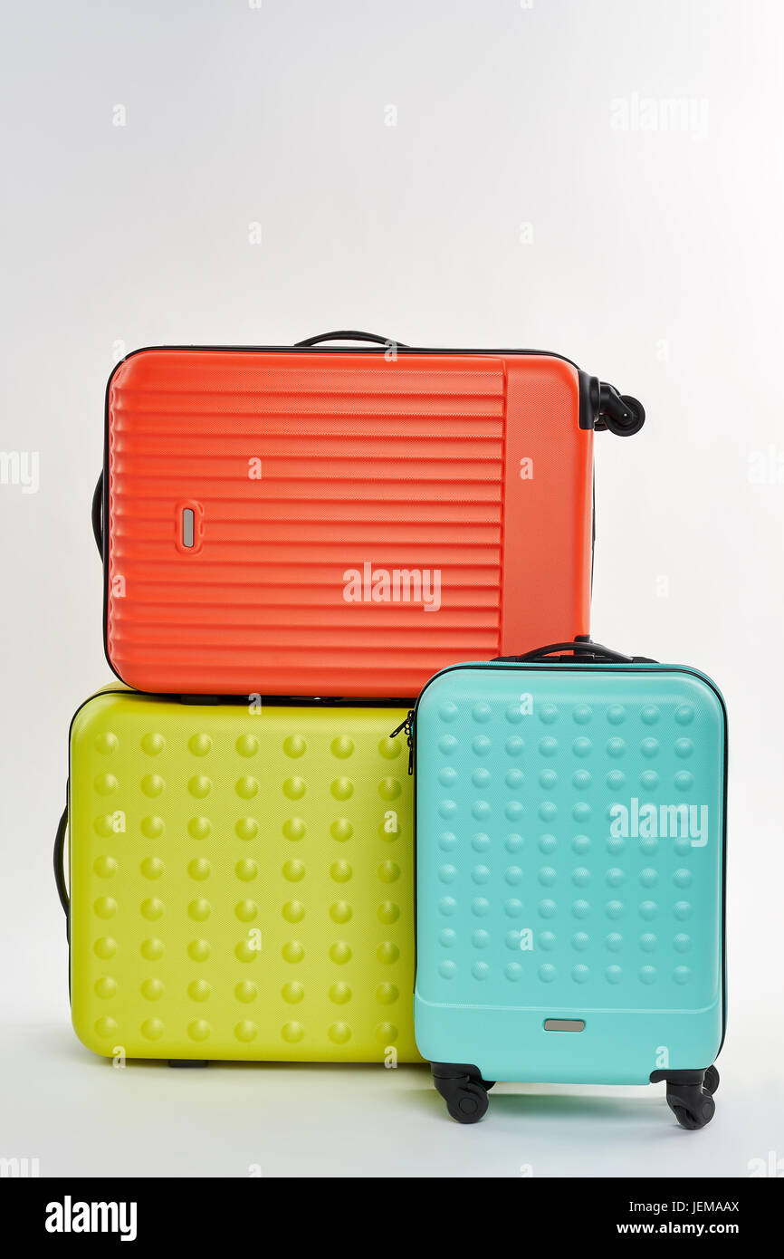 Three colorful suitcases, white background. Luggage for summer ...