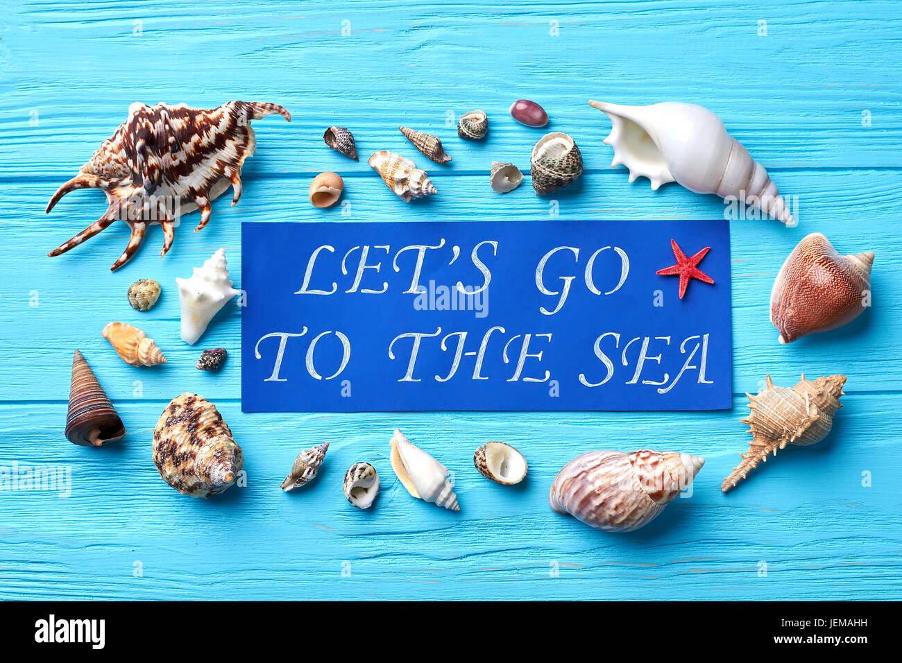 Composition from sea shells, paper note. Sea shells around blue paper ...