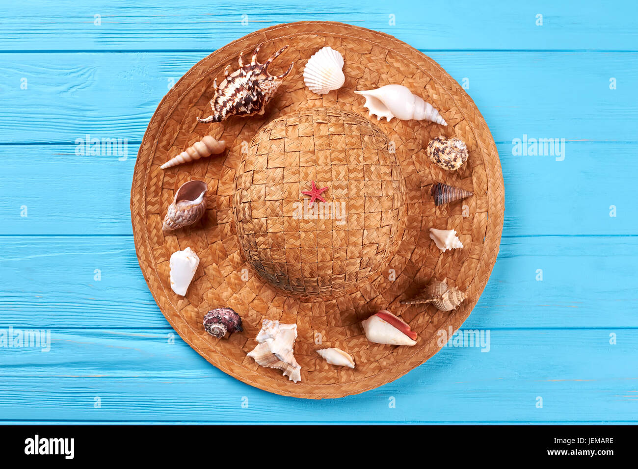 Sea shells on straw hat. Woven hat, sea shells, blue vintage background ...