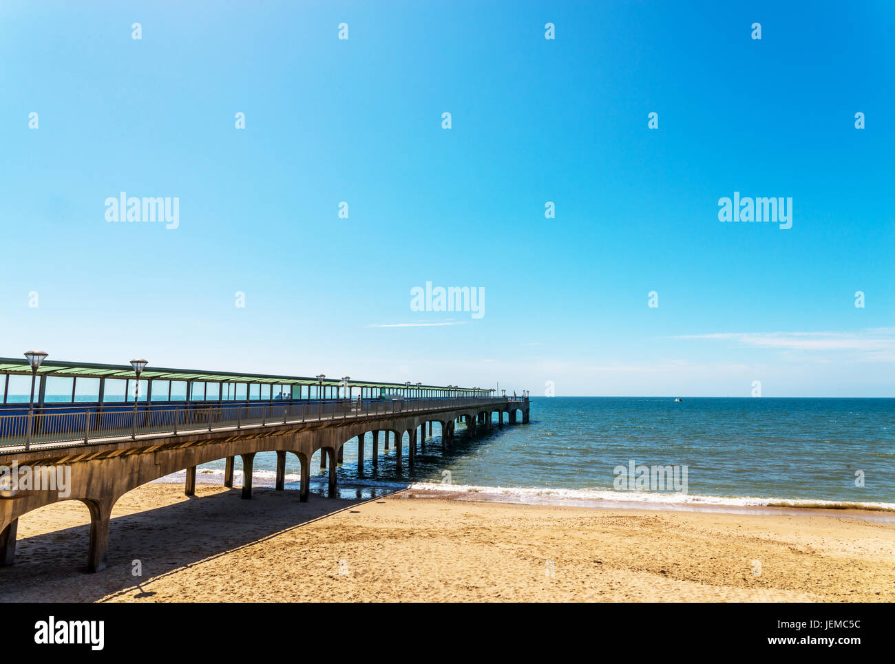 Empty pier over the ocean bay, beautiful blue ocean pane, blue sunny sky, wooden pier, vacation ...