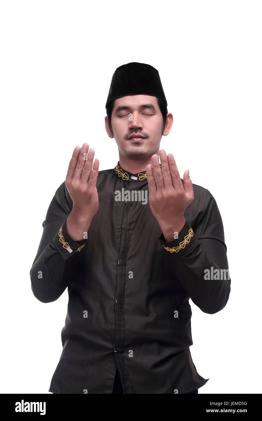 Young asian muslim man with cap praying isolated over white background ...