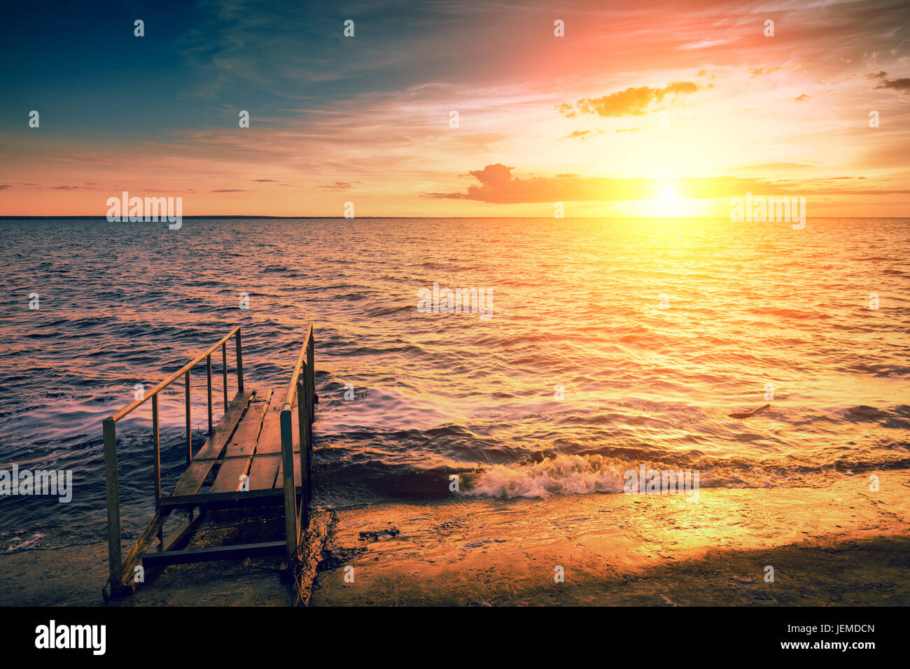 Evening on the beach, sunset over sea, pier on the sea Stock Photo - Alamy