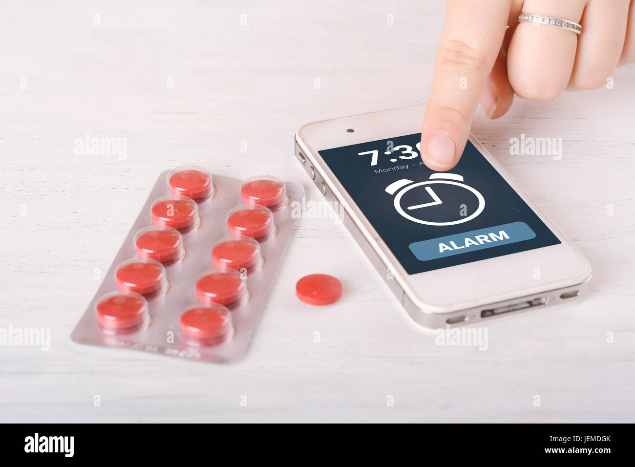 Close-up of cellphone alarm with pills. Medicine time and technology ...