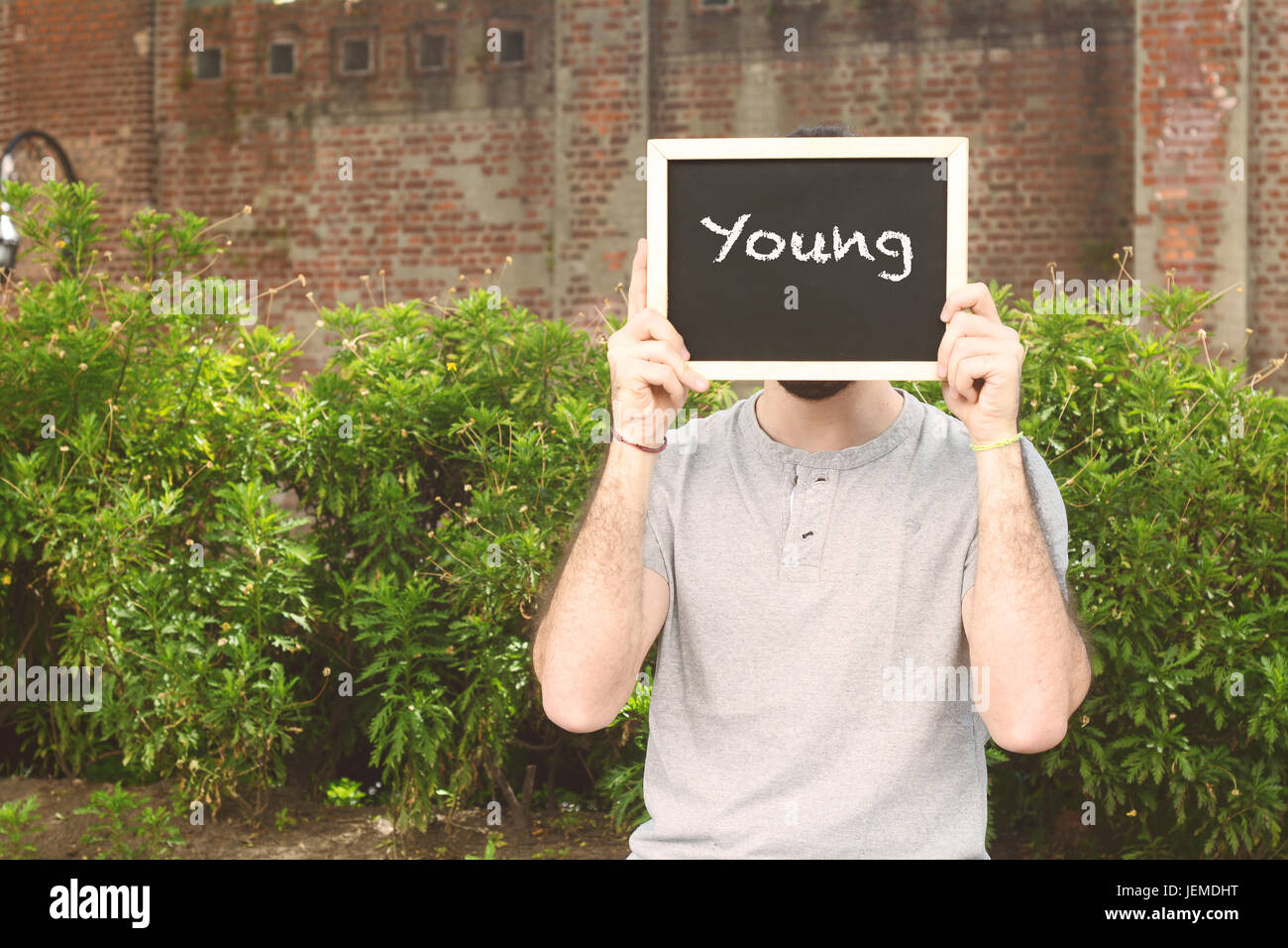 Portrait of handsome young man holding chalkboard with text "healthy ...