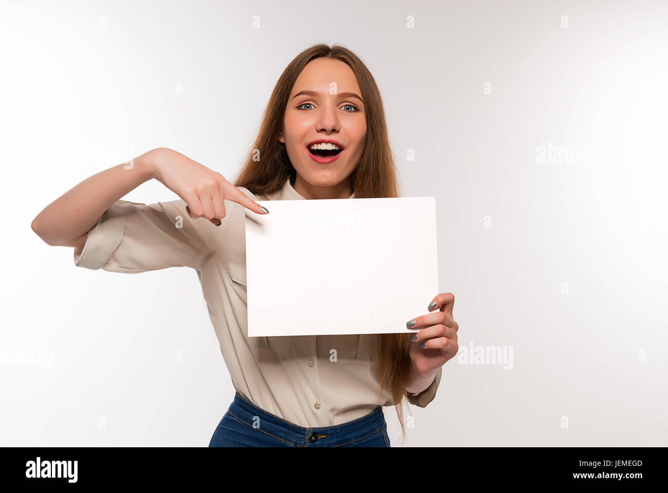 The girl is holding a sheet of paper in front of her Stock Photo - Alamy