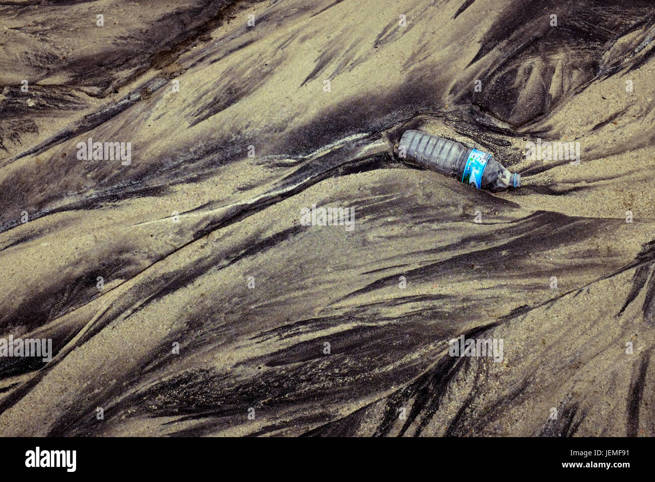 Plastic bottle on dry mud Stock Photo - Alamy