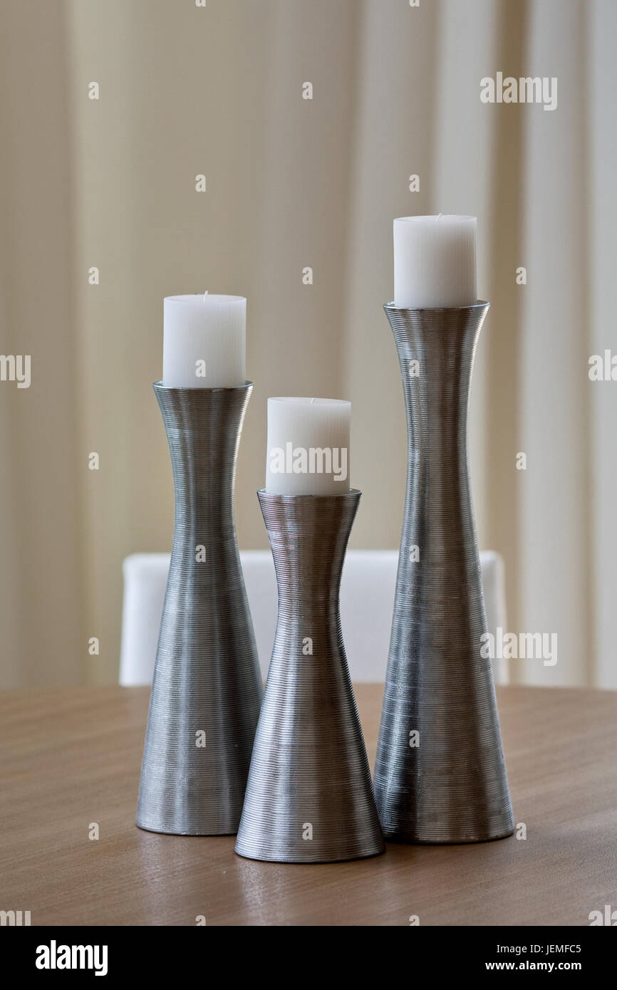 Modern design stainless steel candlesticks in a warm, tasteful interior ...