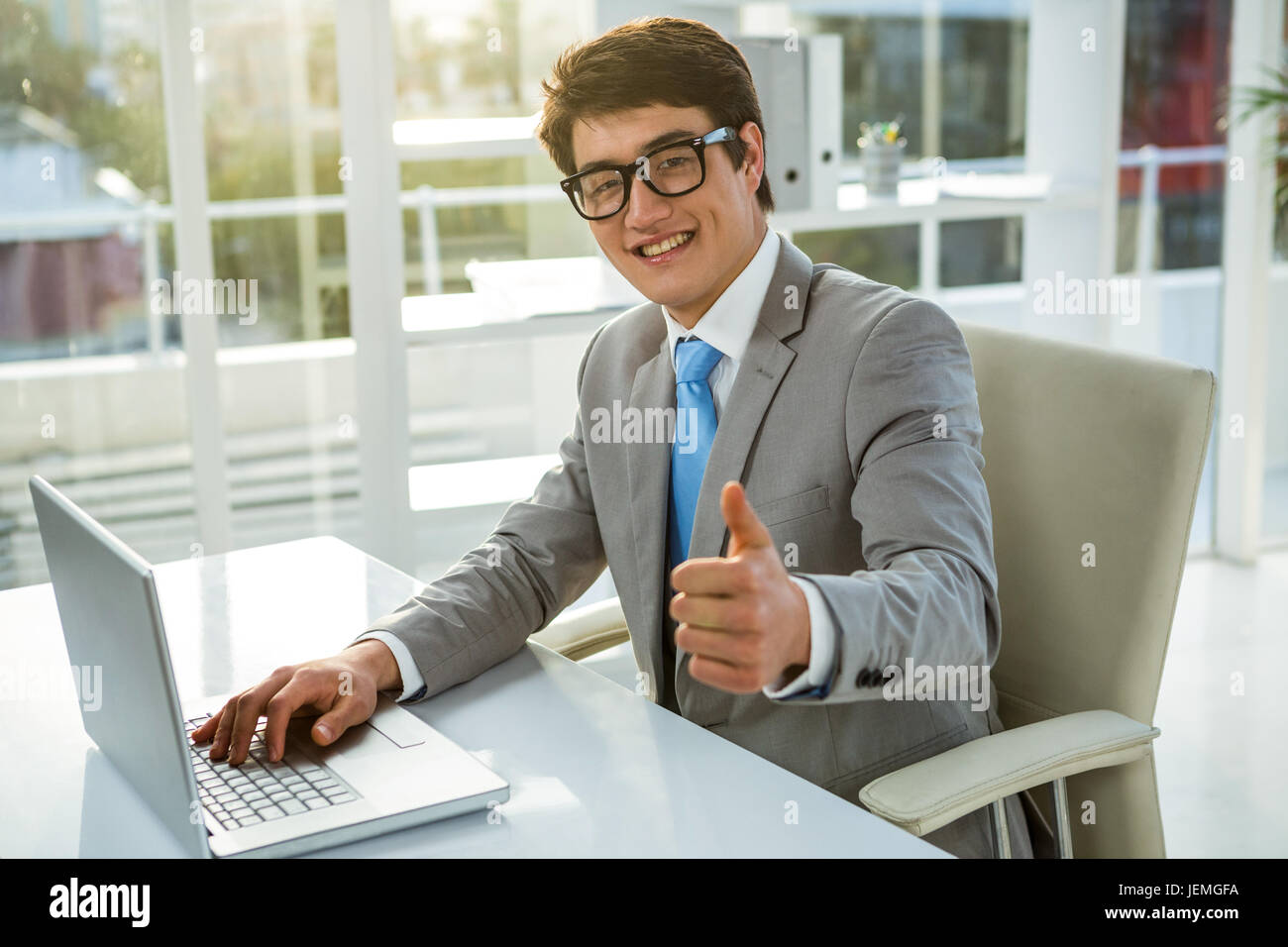 Smiling businessman showing thumbs up Stock Photo - Alamy