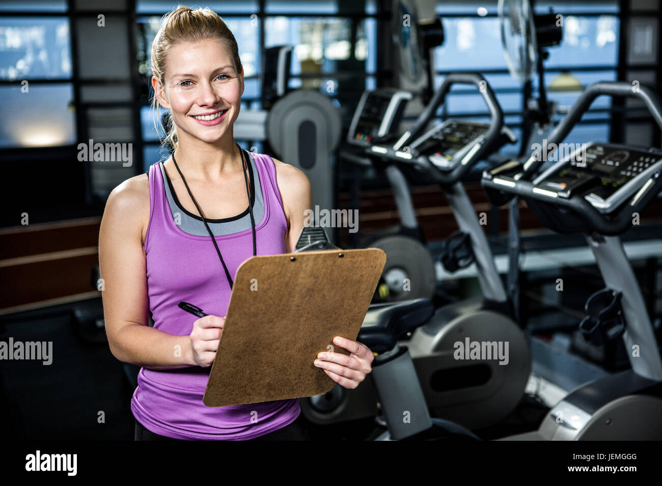 Smiling trainer holding clipboard Stock Photo - Alamy
