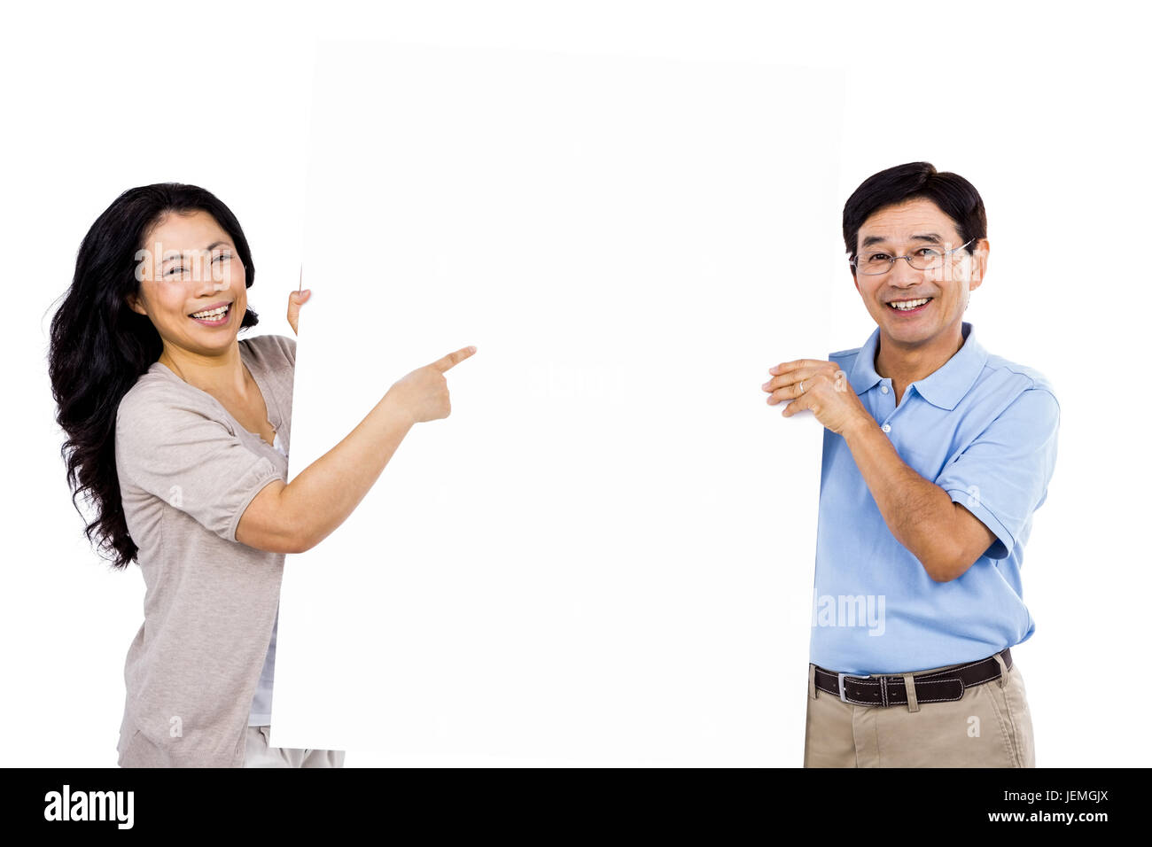 Smiling couple holding up a large sign Stock Photo - Alamy