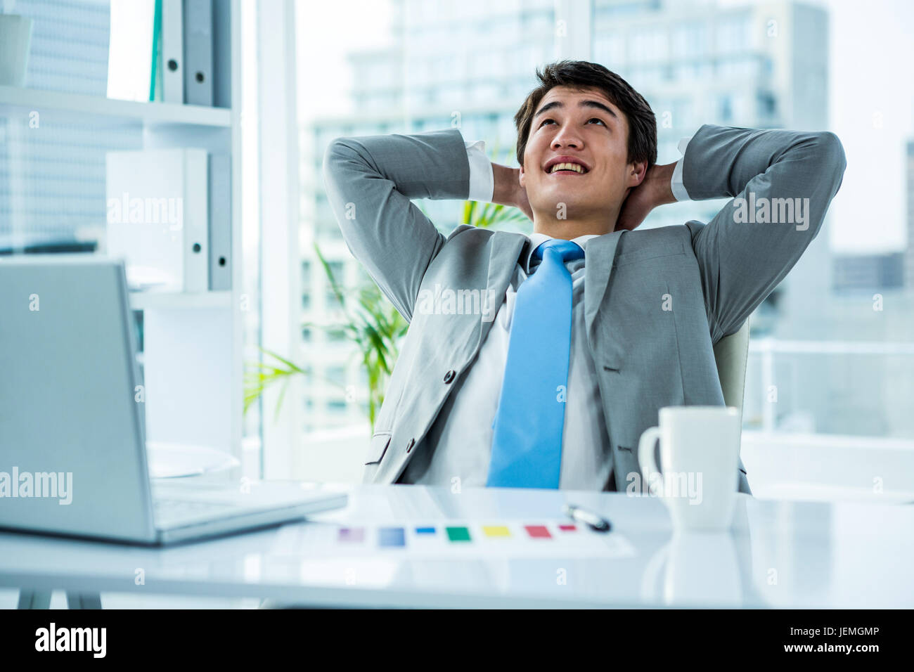 Relaxing asian businessman at his desk Stock Photo - Alamy
