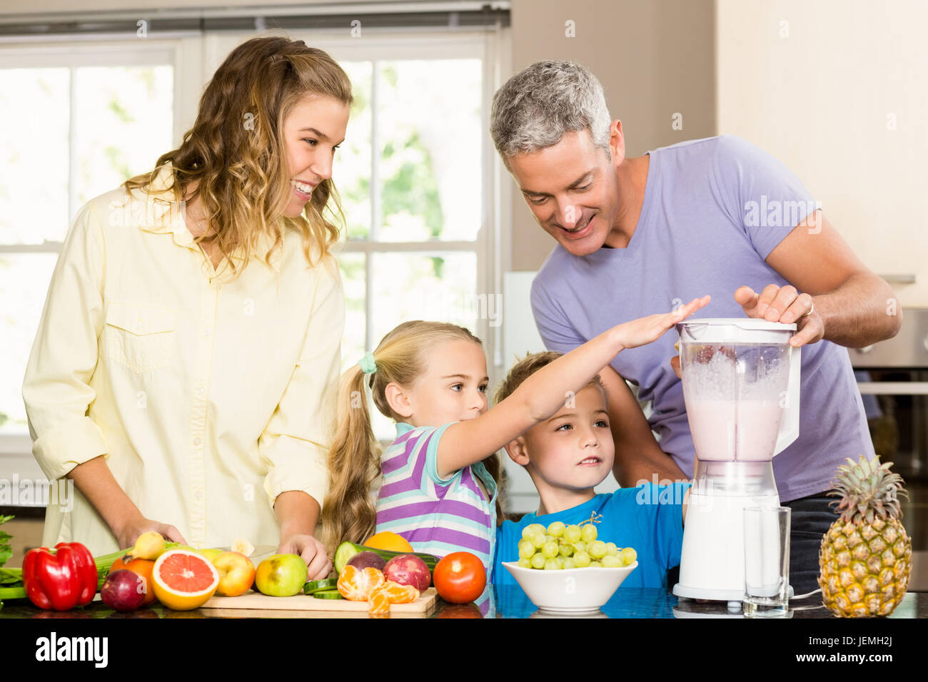Happy family preparing healthy smoothie Stock Photo - Alamy