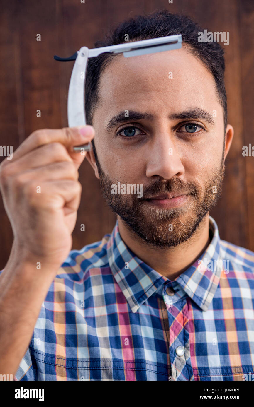 Portrait of businessman holding razor Stock Photo - Alamy