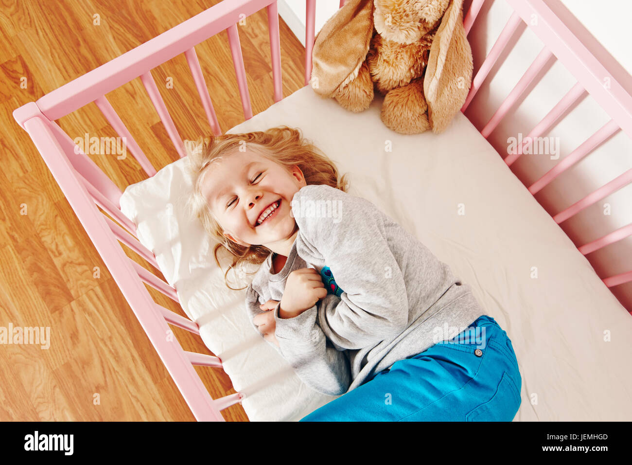 Laughing girl in cot Stock Photo - Alamy
