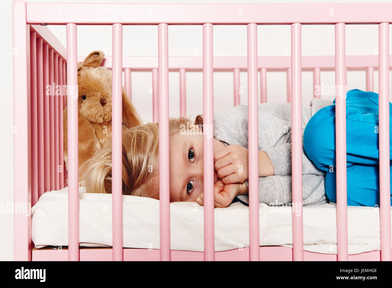 Girl in cot looking at camera Stock Photo - Alamy