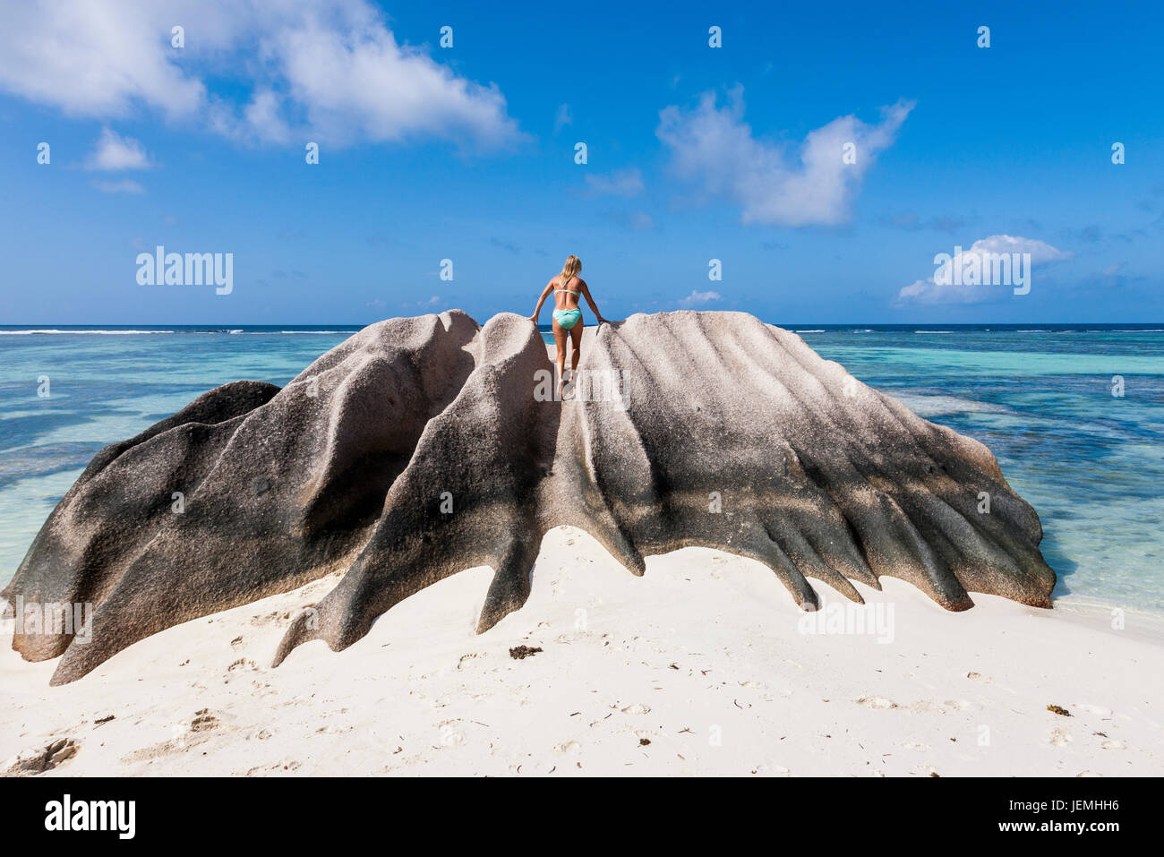Woman on rock at beach Stock Photo - Alamy