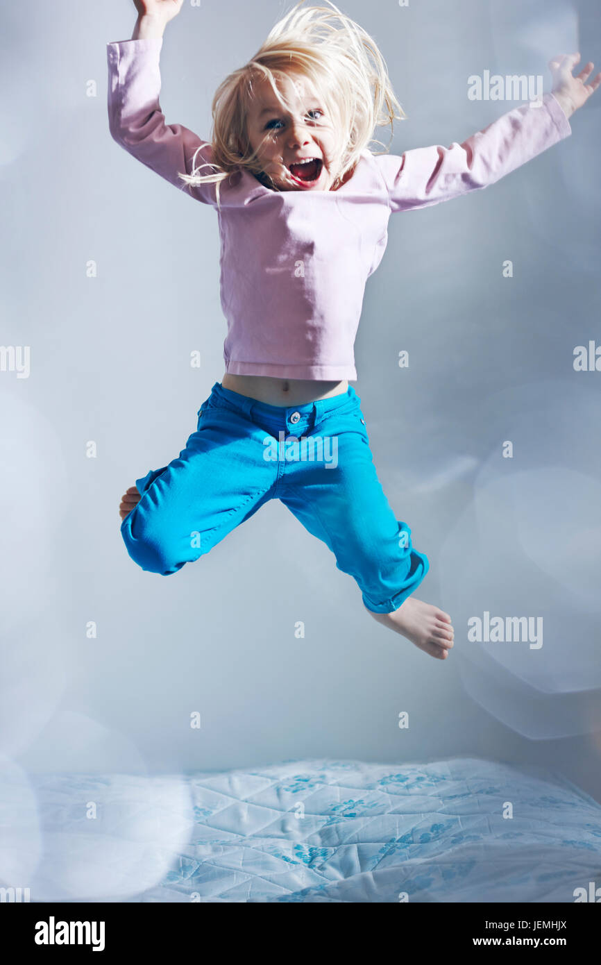 Girl jumping on bed Stock Photo - Alamy