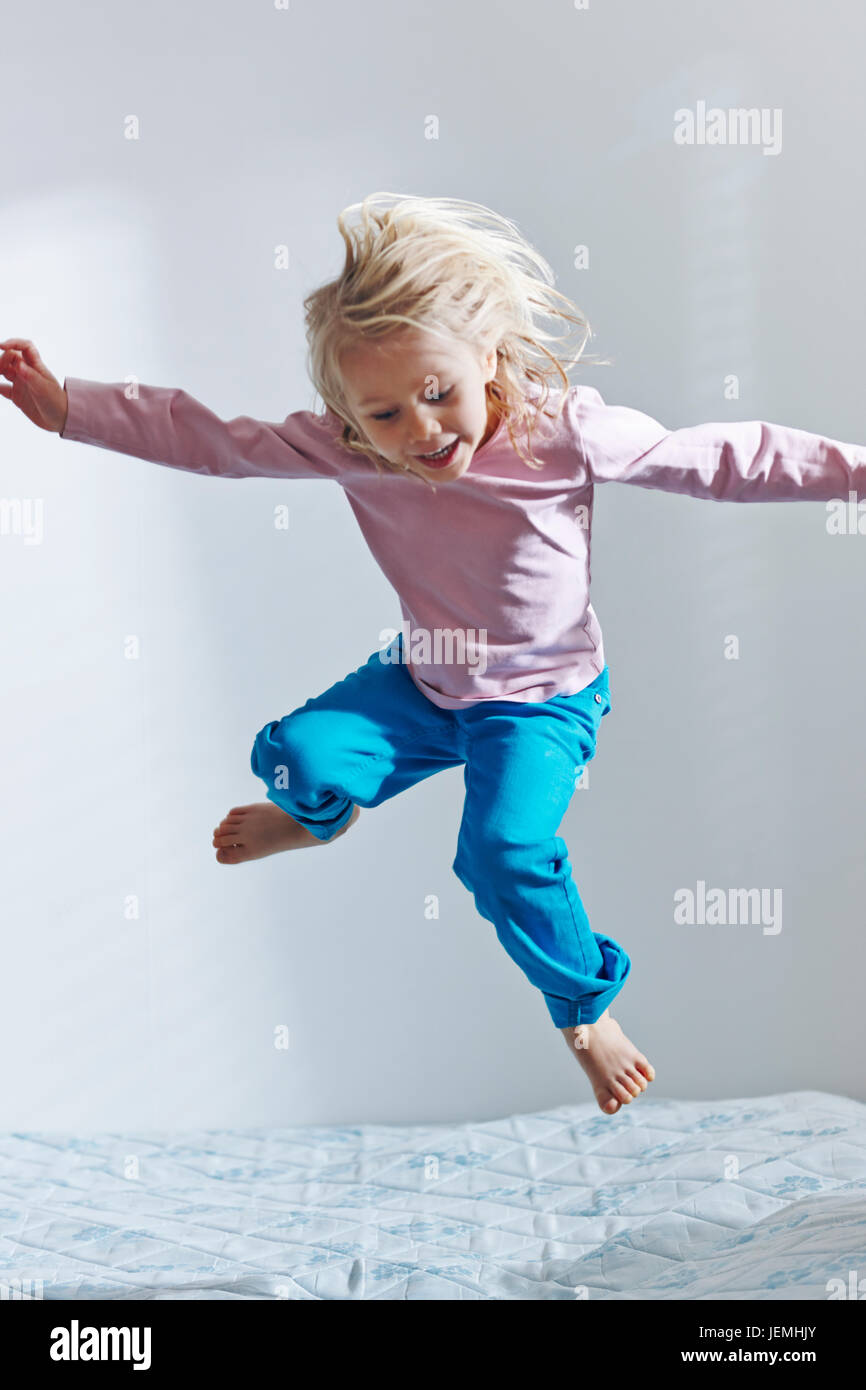 Girl jumping on bed Stock Photo - Alamy