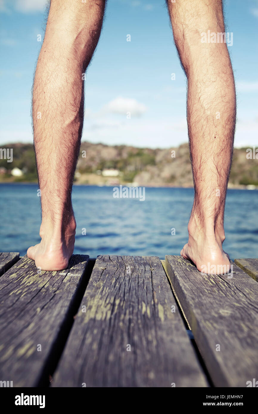 Man on jetty, low section Stock Photo - Alamy