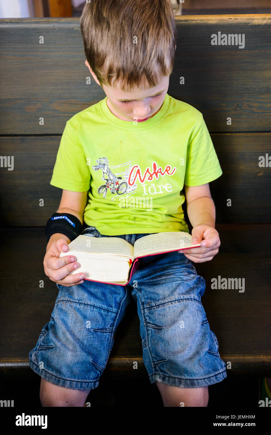 Boy reading book Stock Photo - Alamy
