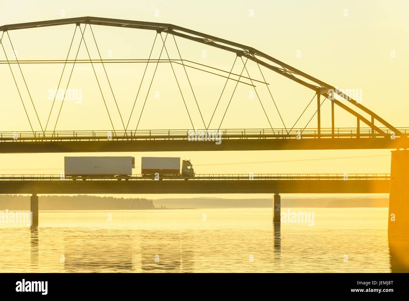 Lorry driving through bridge at sunset Stock Photo - Alamy