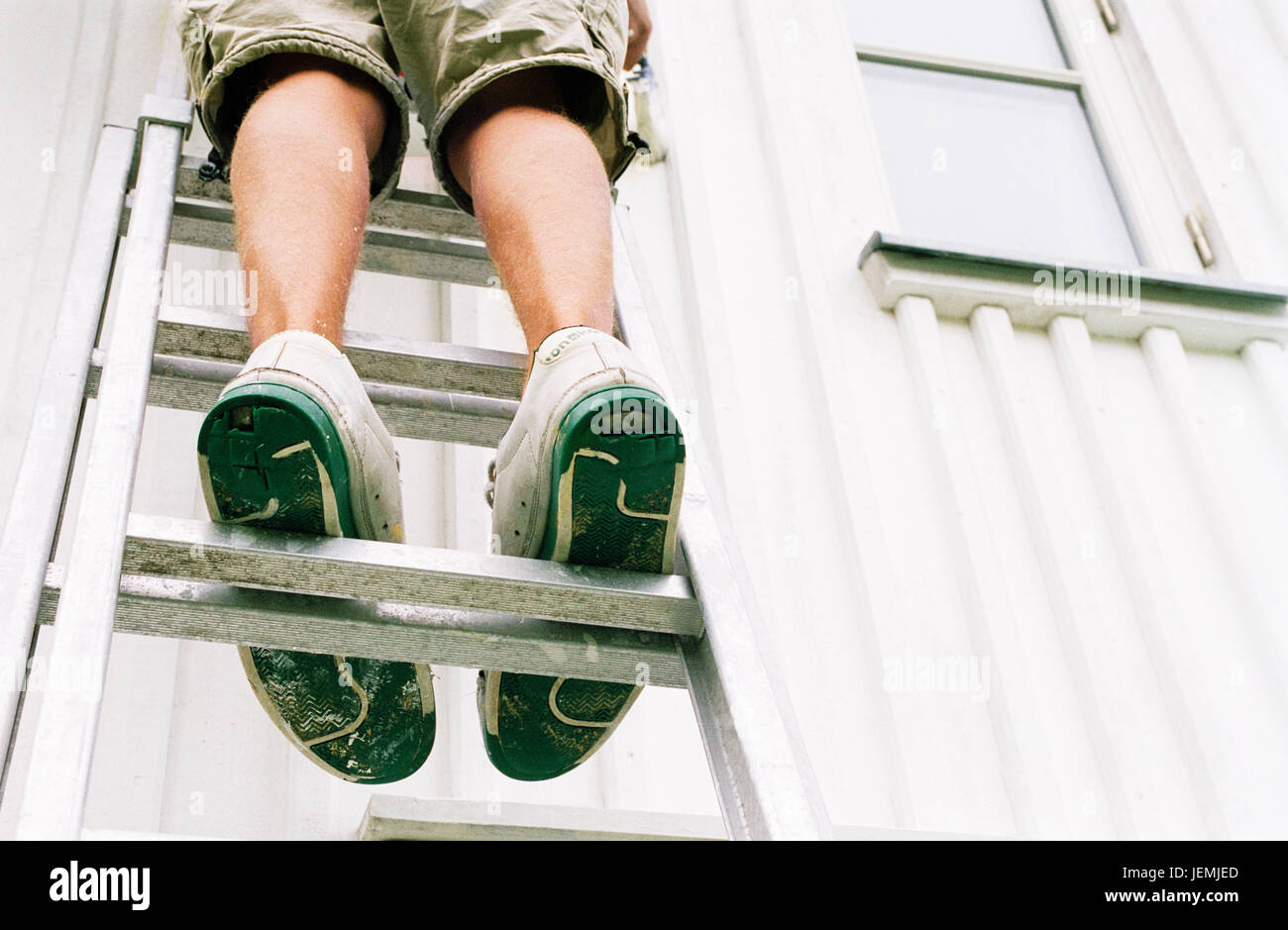Man standing on ladder, low angle view Stock Photo - Alamy