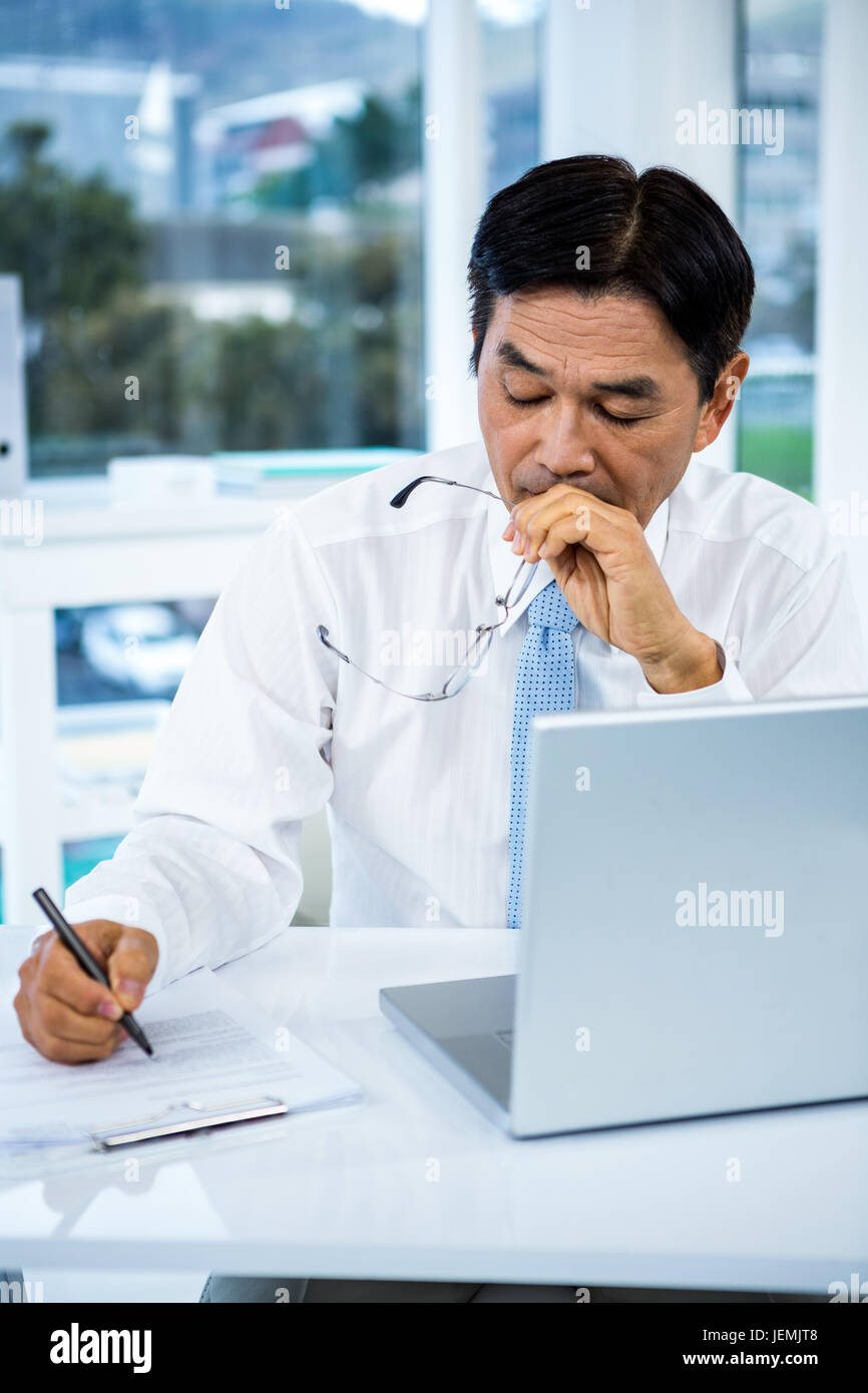 Asian businessman making notes Stock Photo - Alamy