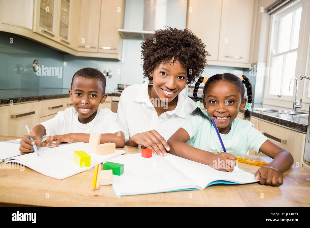 Mother helping children do their homework Stock Photo - Alamy