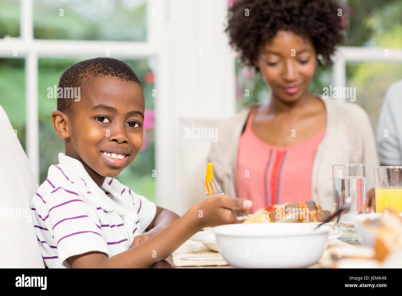 Smiling son eating his dinner Stock Photo - Alamy
