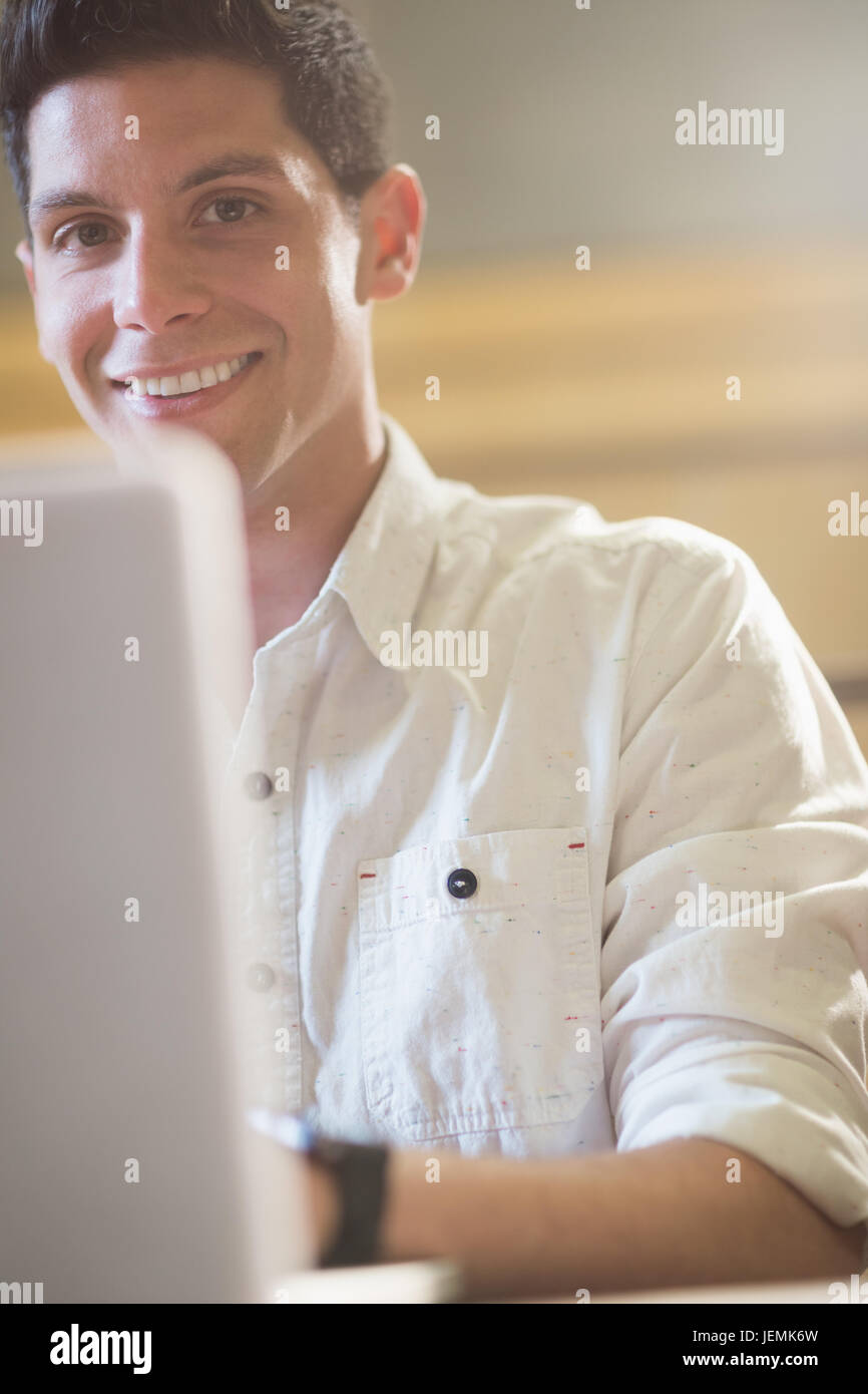Smiling male student using laptop Stock Photo - Alamy