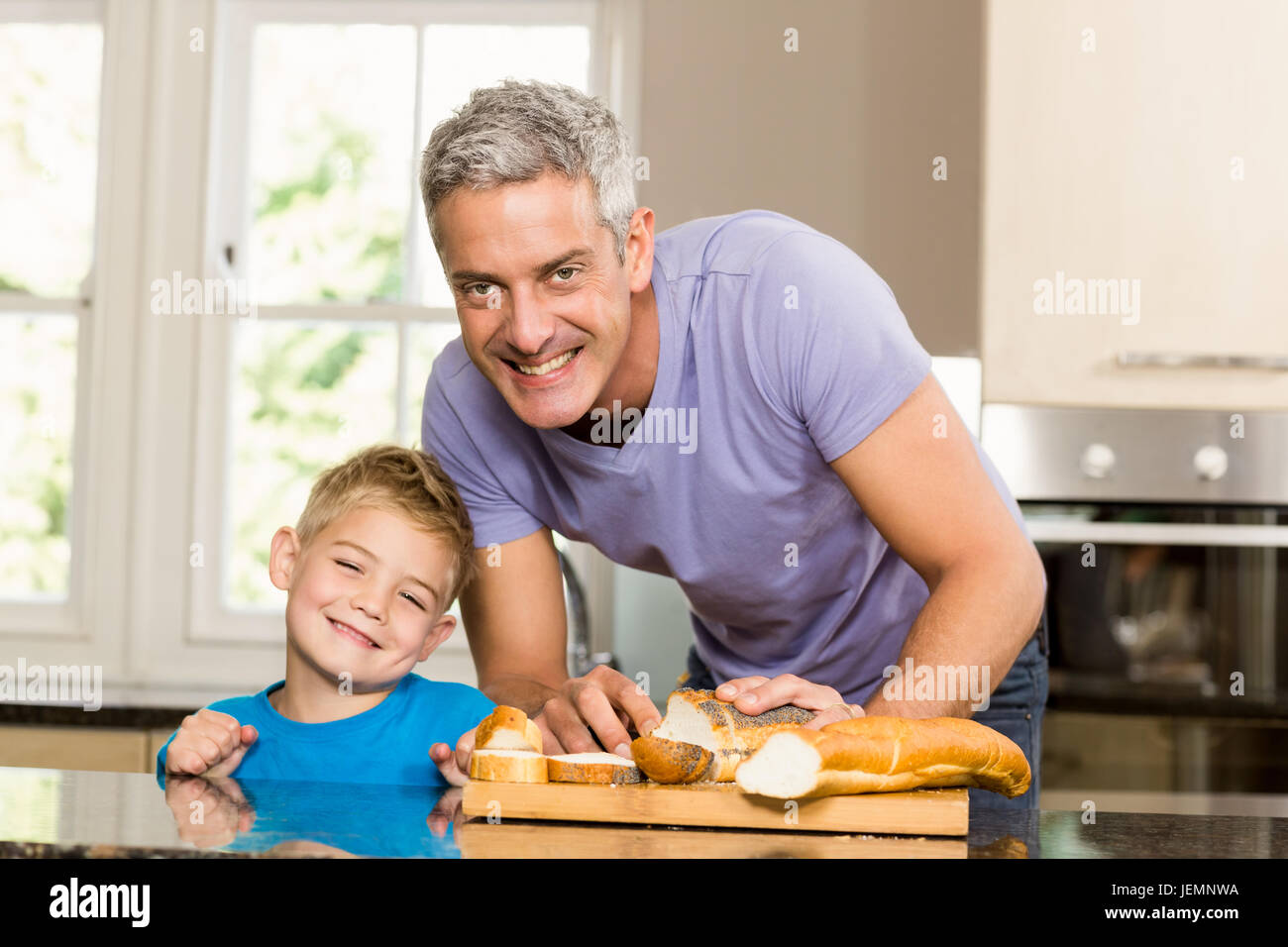 Happy father slicing bread Stock Photo - Alamy