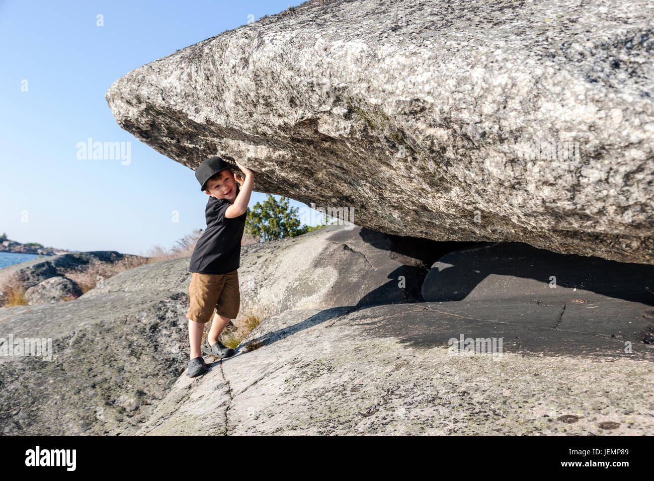 Boy under rock Stock Photo - Alamy