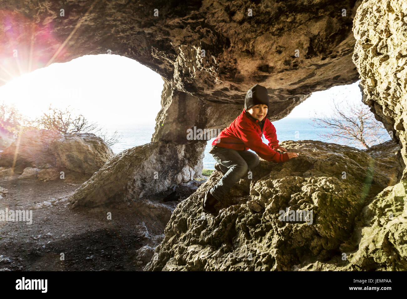 Boy climbing on rock Stock Photo - Alamy