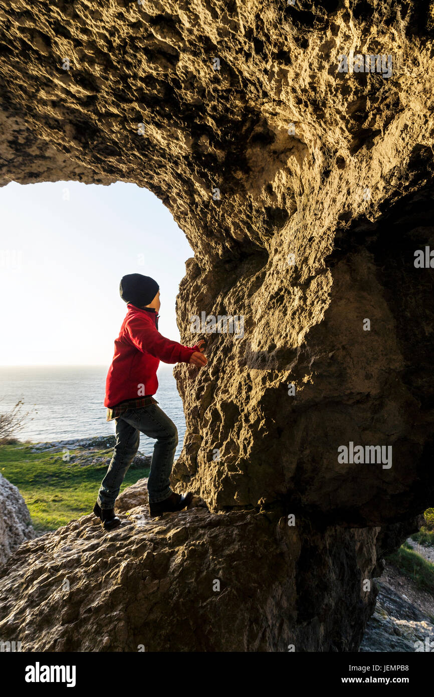 Boy climbing on rock Stock Photo - Alamy
