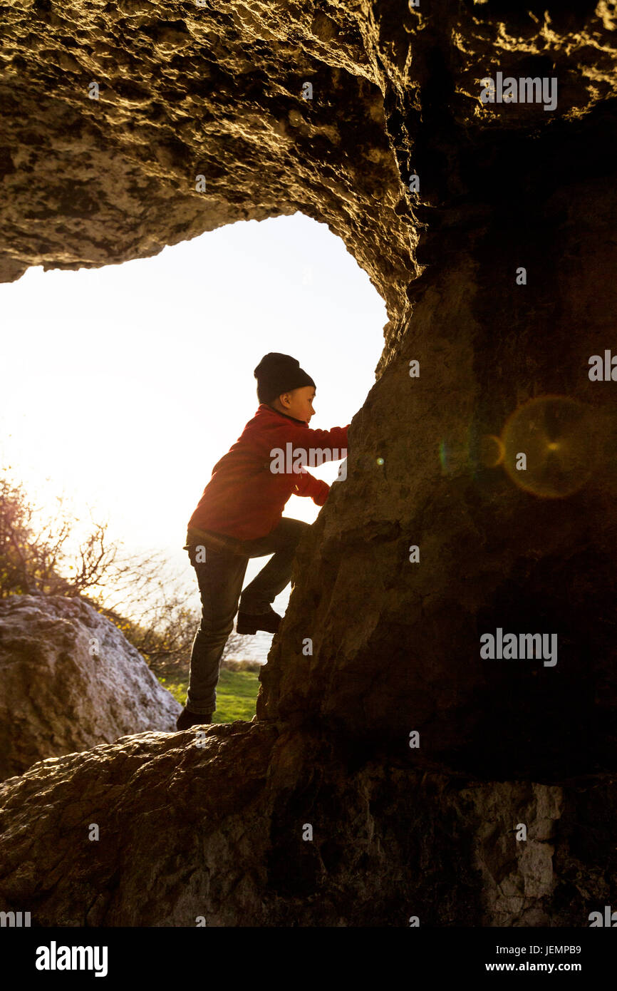 Boy climbing on rock Stock Photo - Alamy