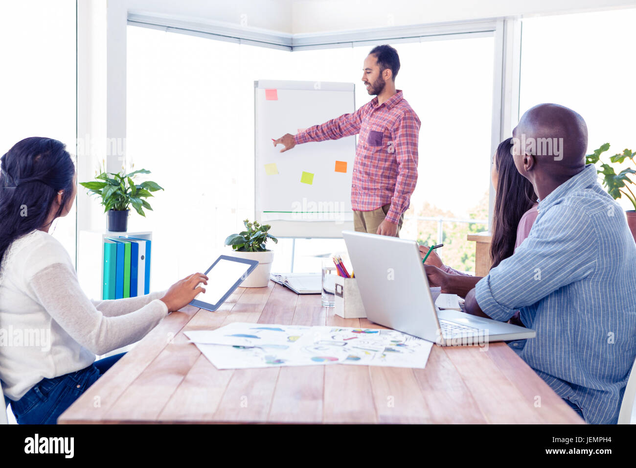 Businessman giving presentation to team Stock Photo - Alamy