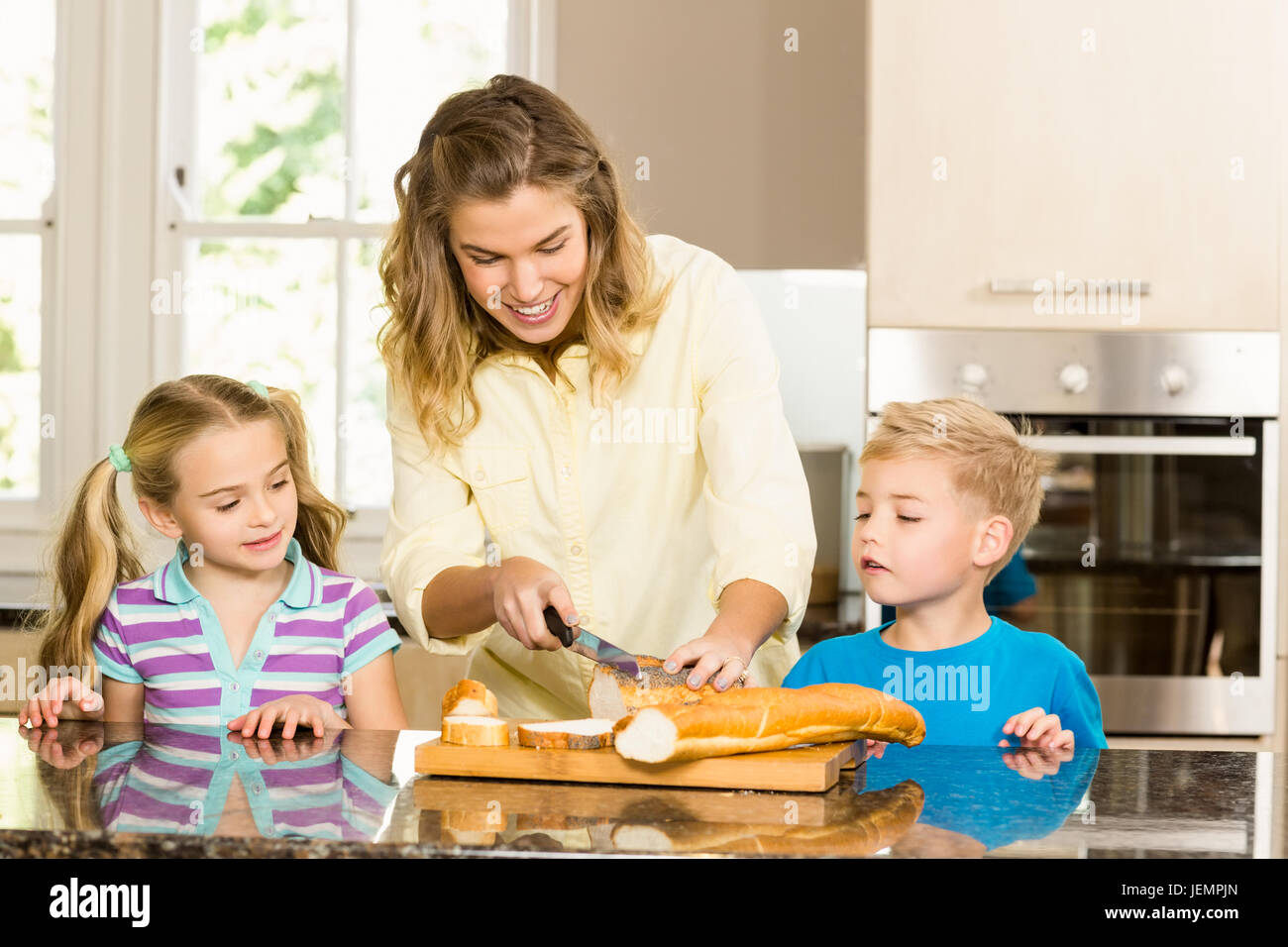 Happy family slicing bread Stock Photo - Alamy