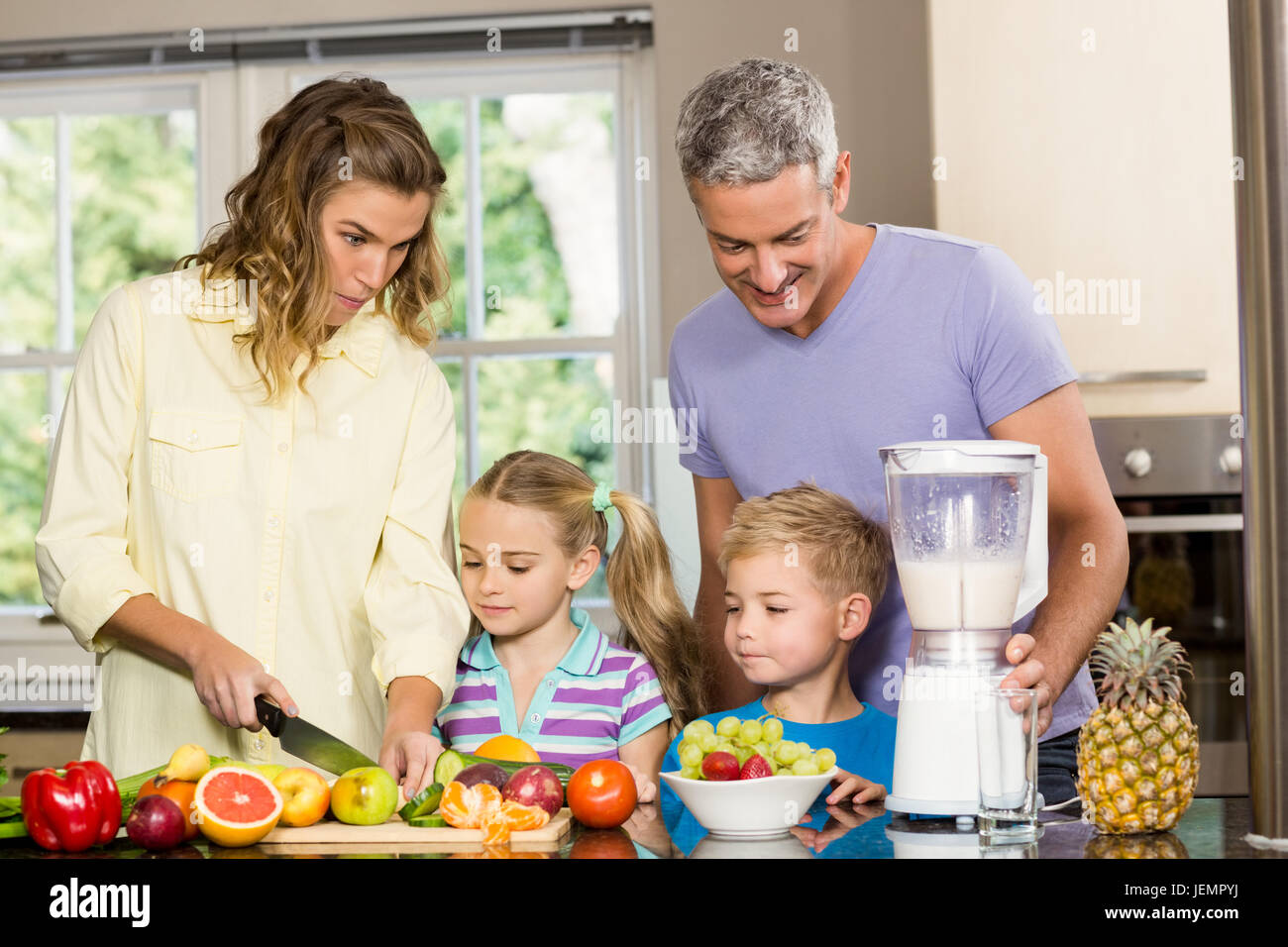 Happy family preparing healthy smoothie Stock Photo - Alamy