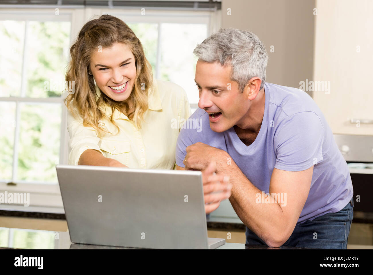 Happy couple using laptop together Stock Photo - Alamy