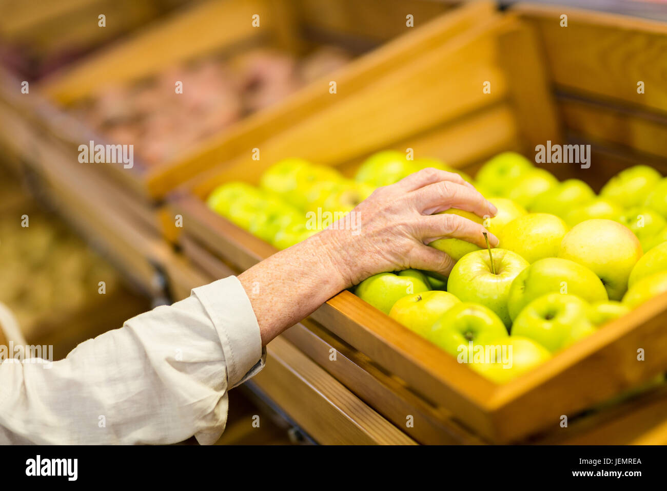 Senior woman picking out a green apple Stock Photo - Alamy