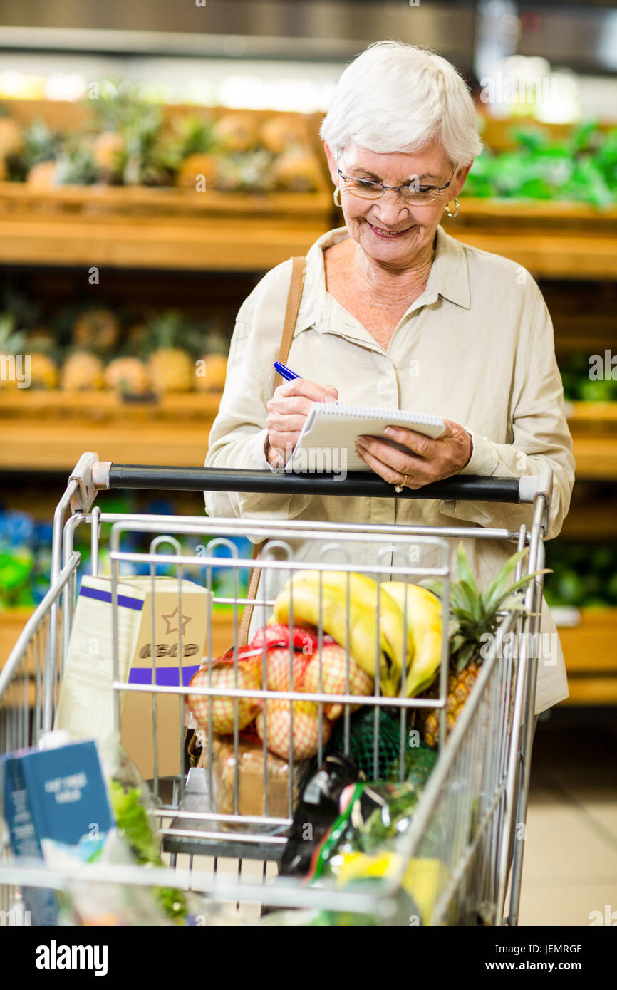 Smiling senior woman checking list Stock Photo - Alamy