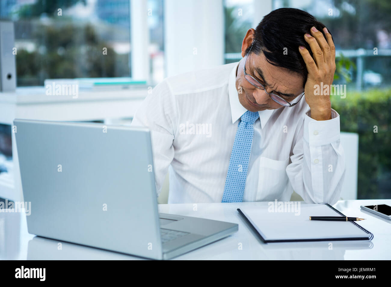 Worried businessman working at his desk Stock Photo - Alamy