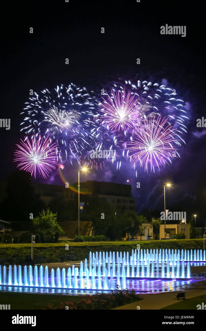 Brightly colorful fireworks above the city water fountains during the ...