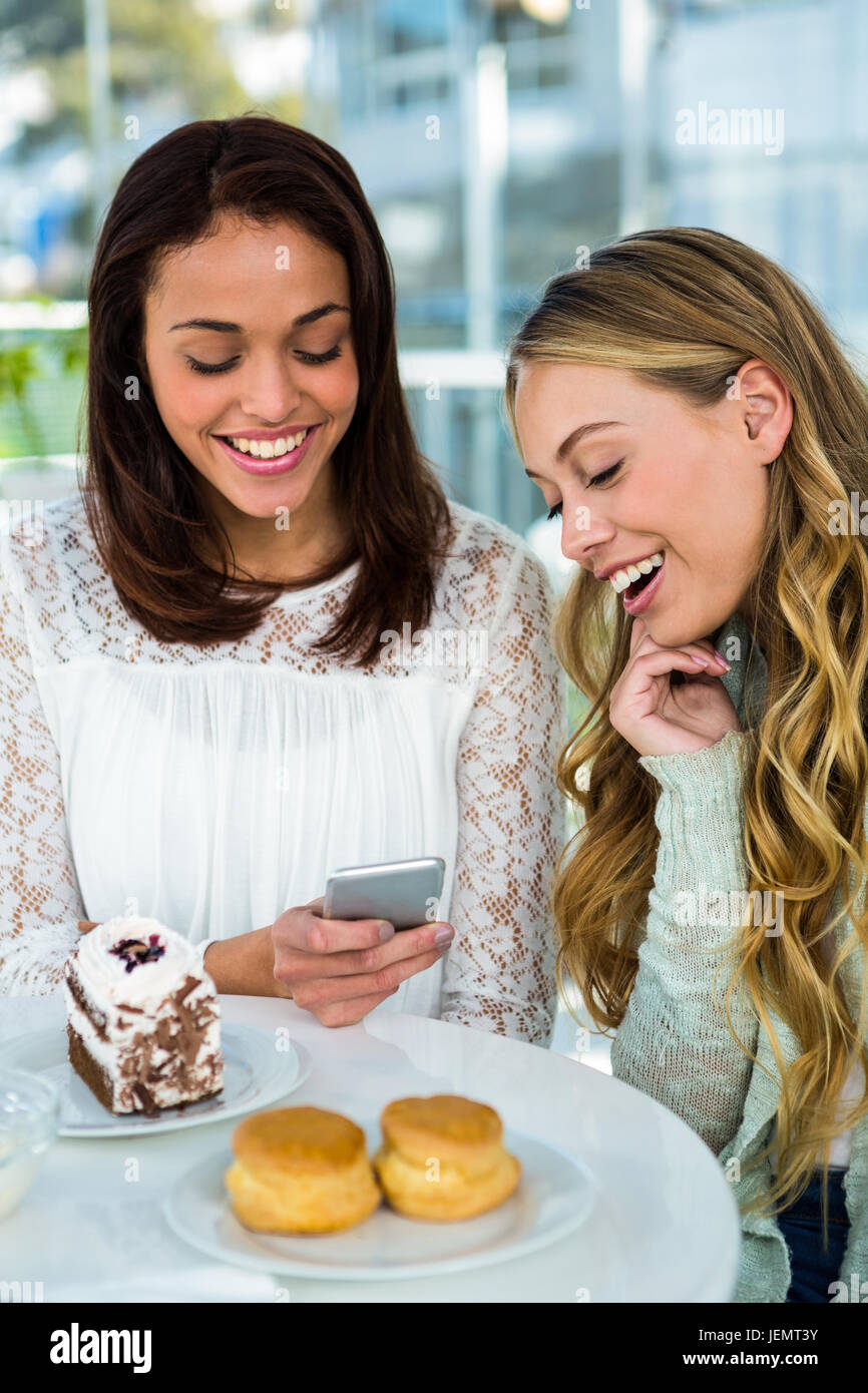 two girls watch a phone Stock Photo - Alamy