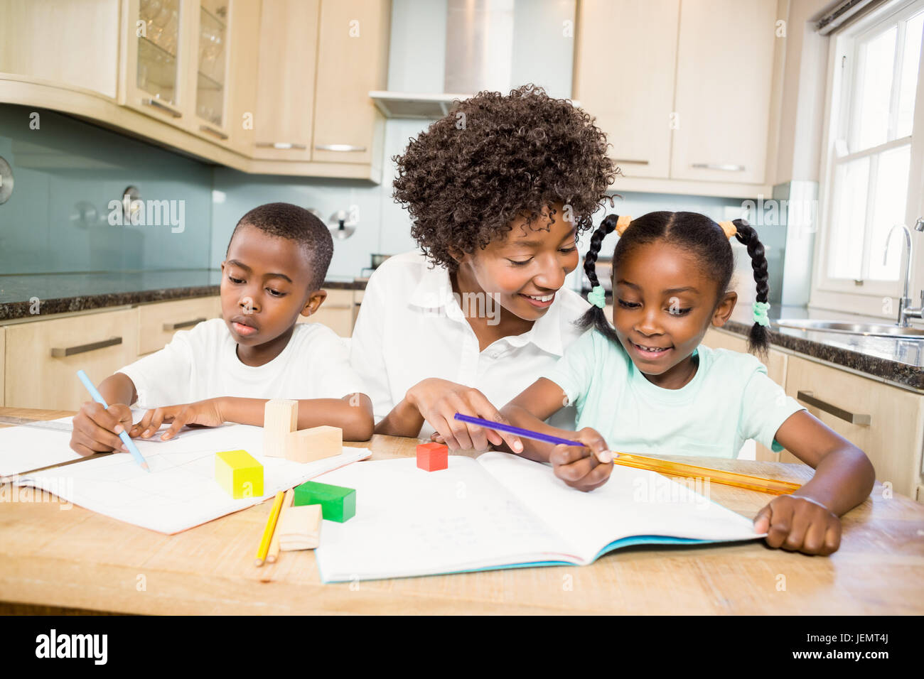 Mother checking children homework Stock Photo - Alamy