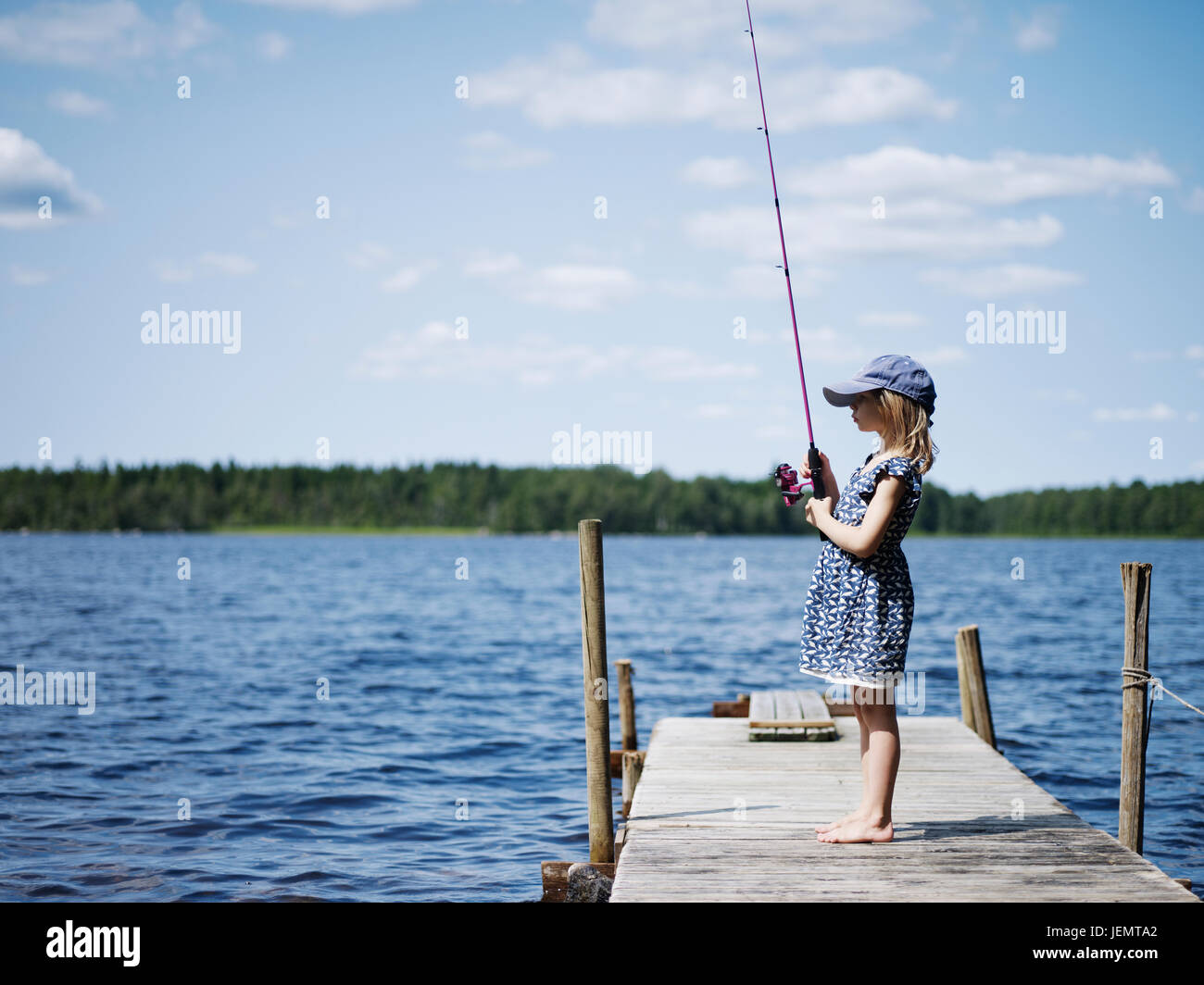 Girl fishing on jetty Stock Photo - Alamy